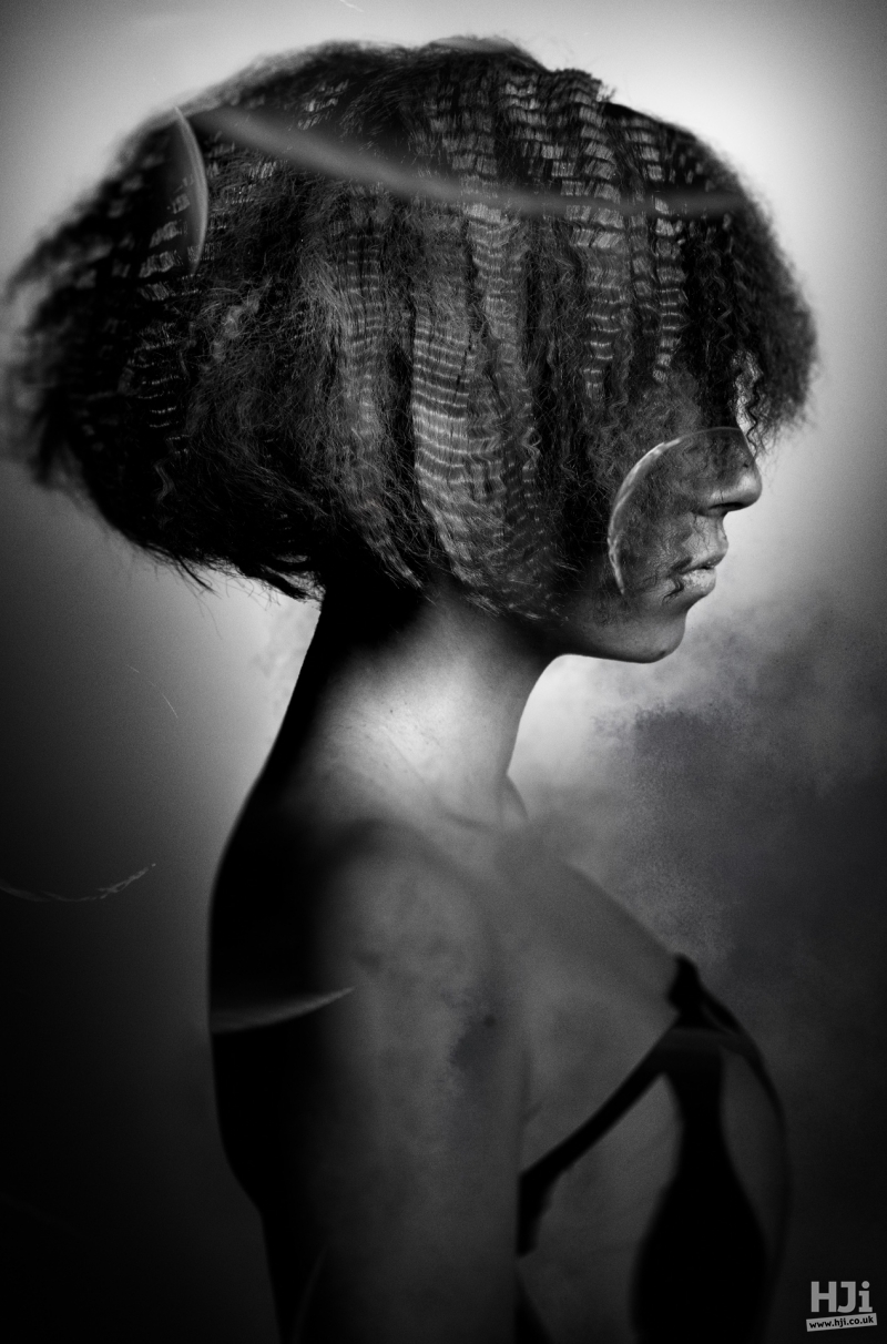 Black, textured afro with sun-kissed appearance highlights, styled into ...